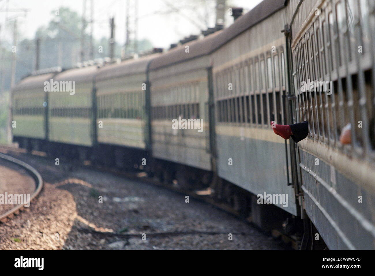 --FILE--A passenger stretches his feet out of a window of a "green-skin ...