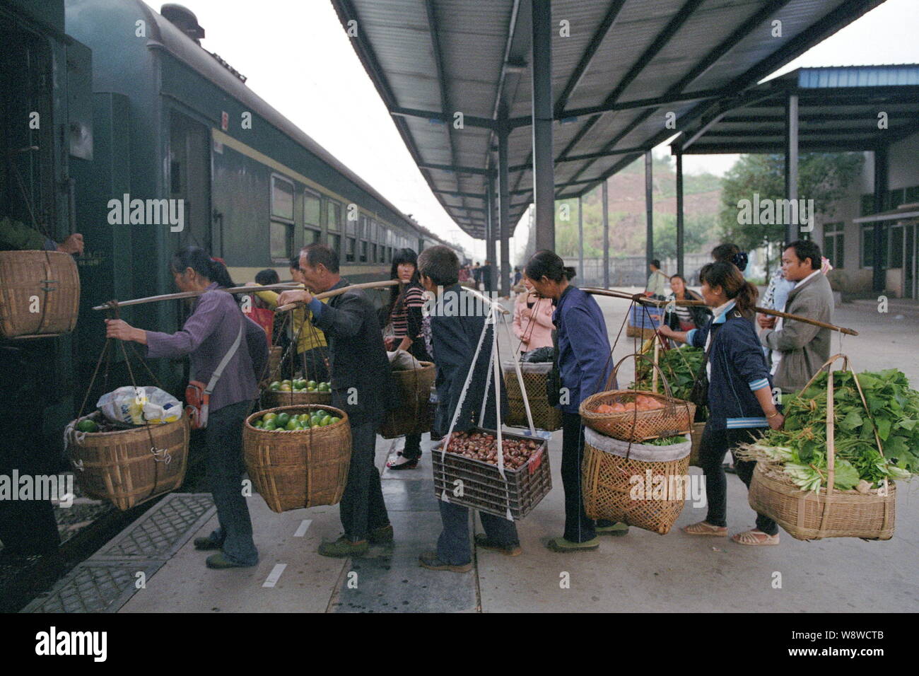 --FILE--Chinese farmers shouldering baskets of vegetables and fruit to ...