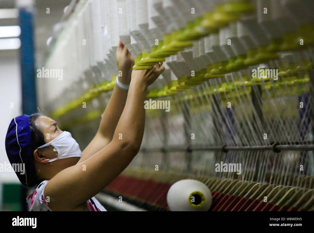 --FILE--A female Chinese worker handles production of yarn at a textile factory in Jiujiang city ...