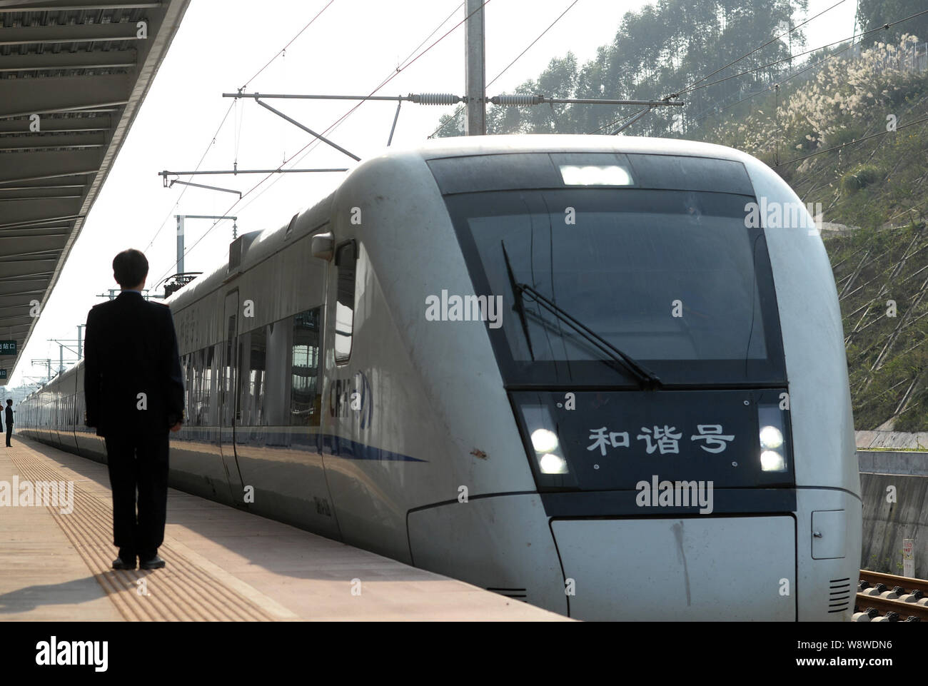 --FILE--A train conductor stands next to a CRH (China Railway High ...