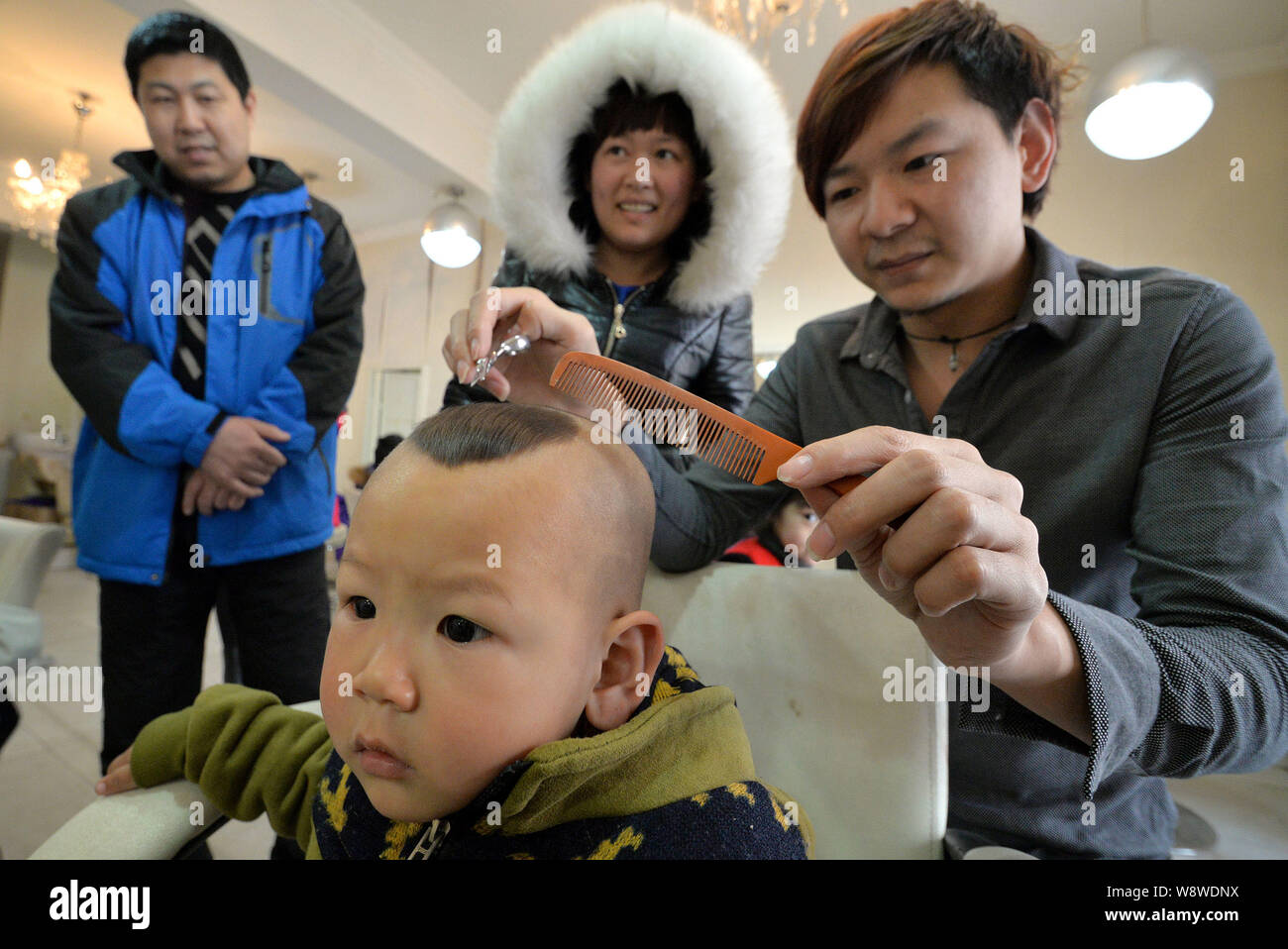A Chinese kid has his hair cut at the barbers on Dragon Heads-raising ...