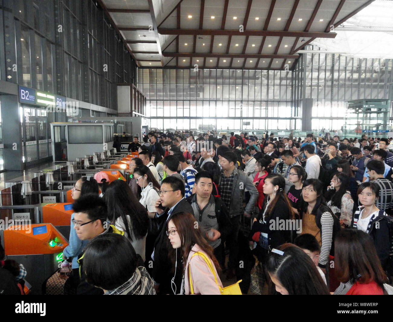 Chinese passengers who return to work from the May Day holiday queue up ...