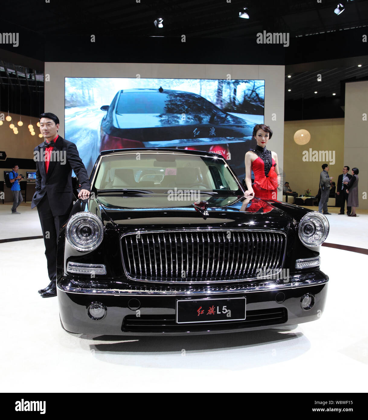 Models pose with a Hongqi (Red Flag) L5 of FAW during the 13th Beijing ...