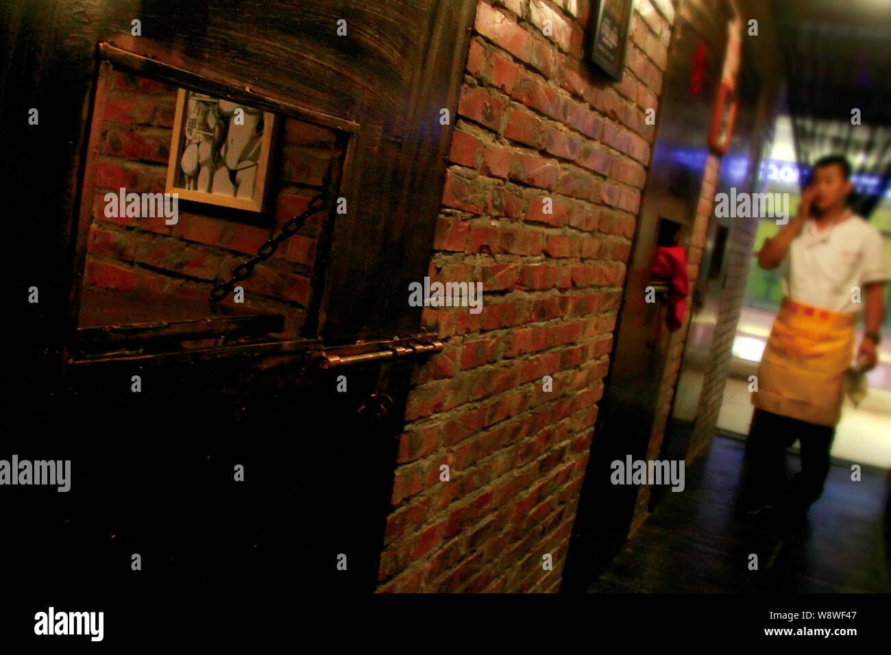 A waiter walks past eating rooms at the first prison-themed restaurant ...