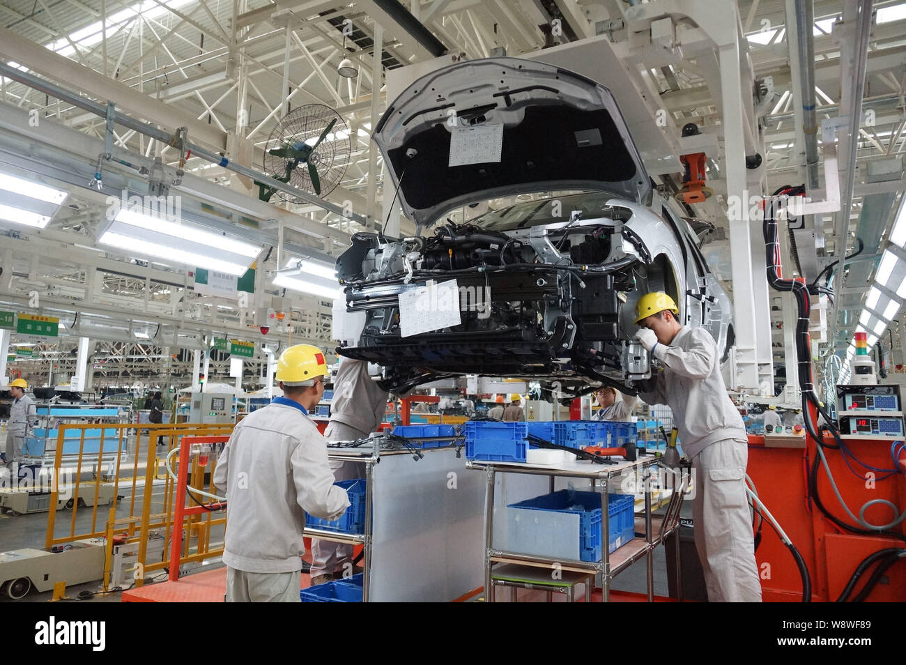 --FILE--Chinese workers assemble a car on the assembly line at the auto ...
