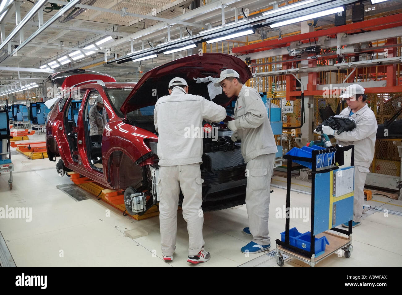 --FILE--Chinese workers assemble a car on the assembly line at the auto ...