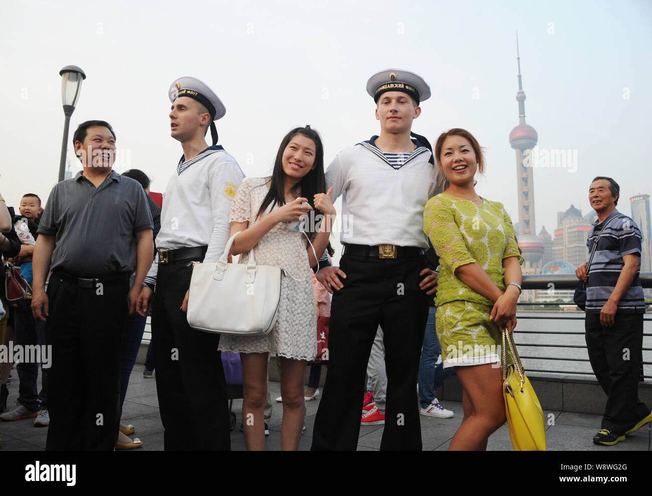 Russian sailors pose for photos with Chinese tourists on the promenade ...