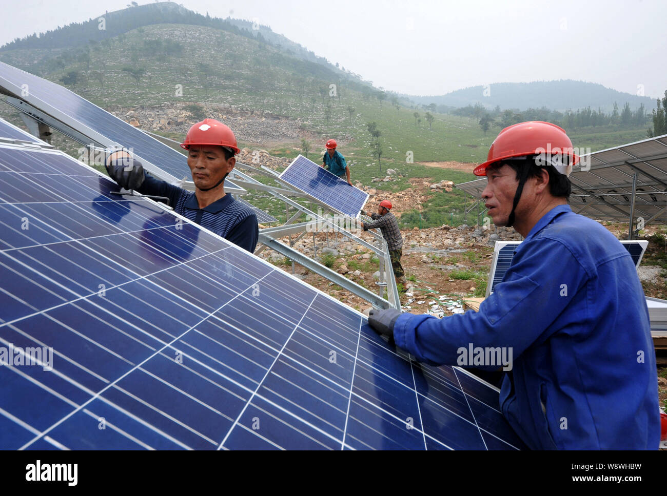 --FILE--Chinese workers install solar panels at a photovoltaic (PV ...