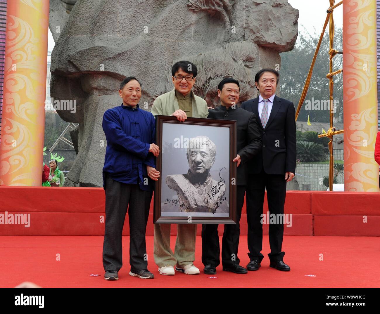 Hong Kong actor Jackie Chan, second left, poses with a portrait of him ...