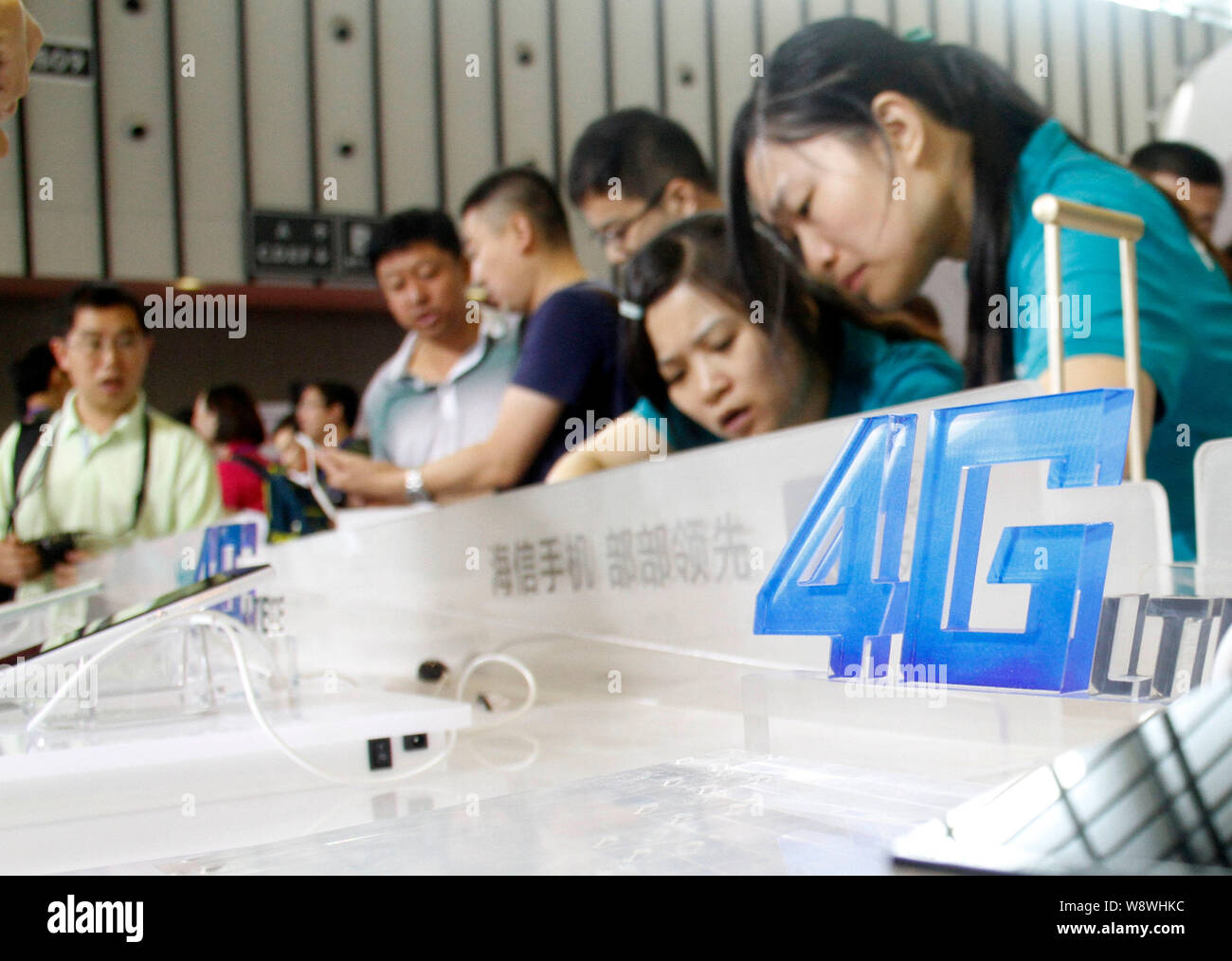 --FILE--Visitors look at Hisense 4G smartphones during the 2014 Tianyi ...