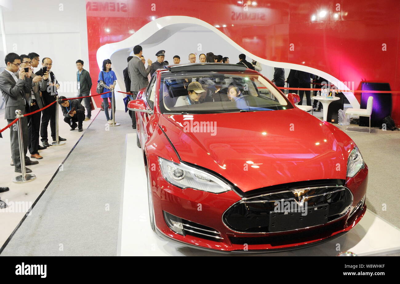 --FILE--Visitors try out or look at a Tesla Model S electric car during ...