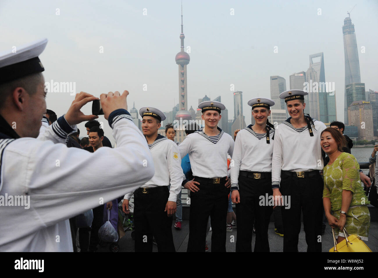 Russian sailors pose for photos with a Chinese tourist on the promenade ...