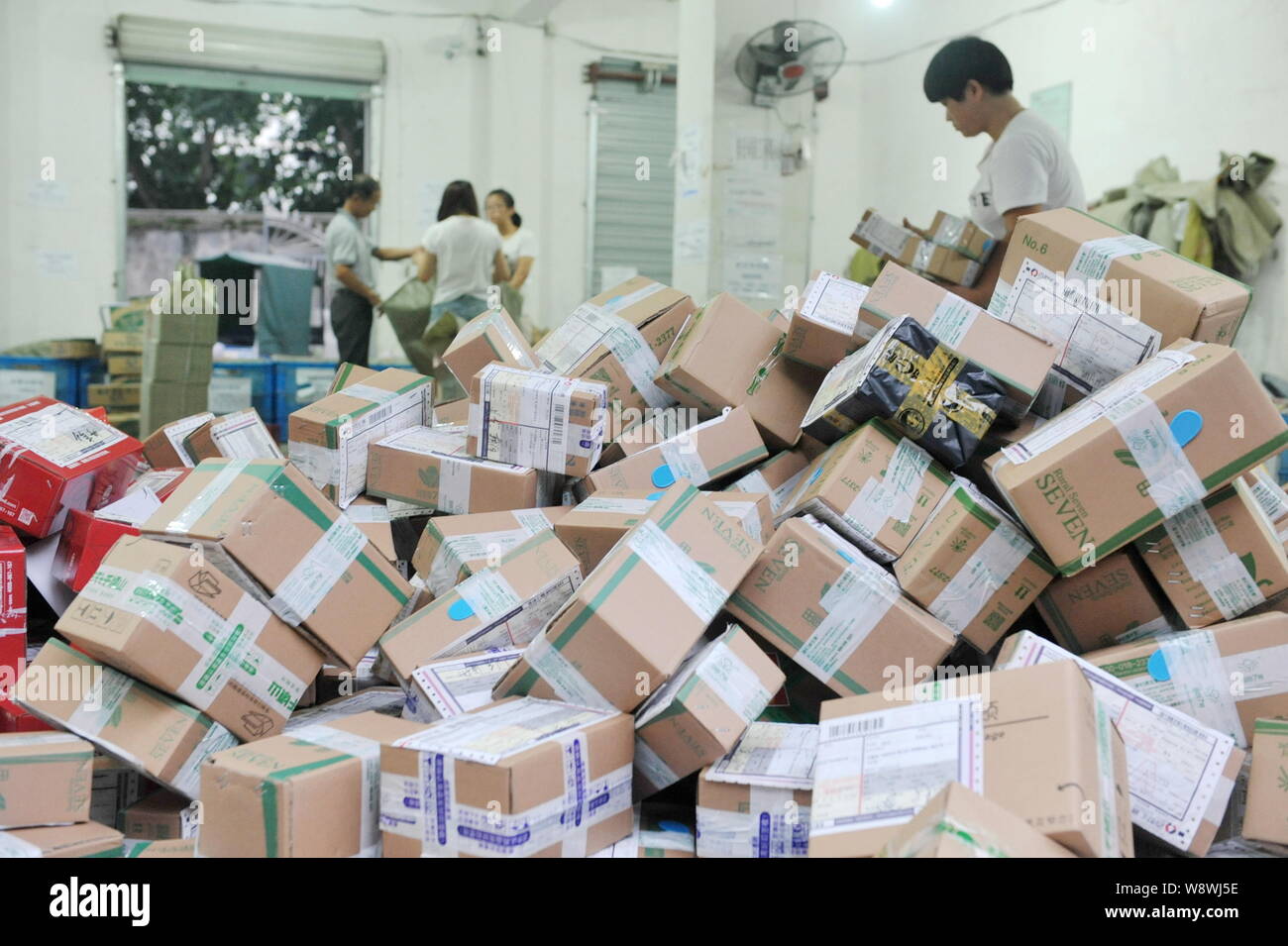 --FILE--Chinese workers sort parcels at a distribution station of an ...