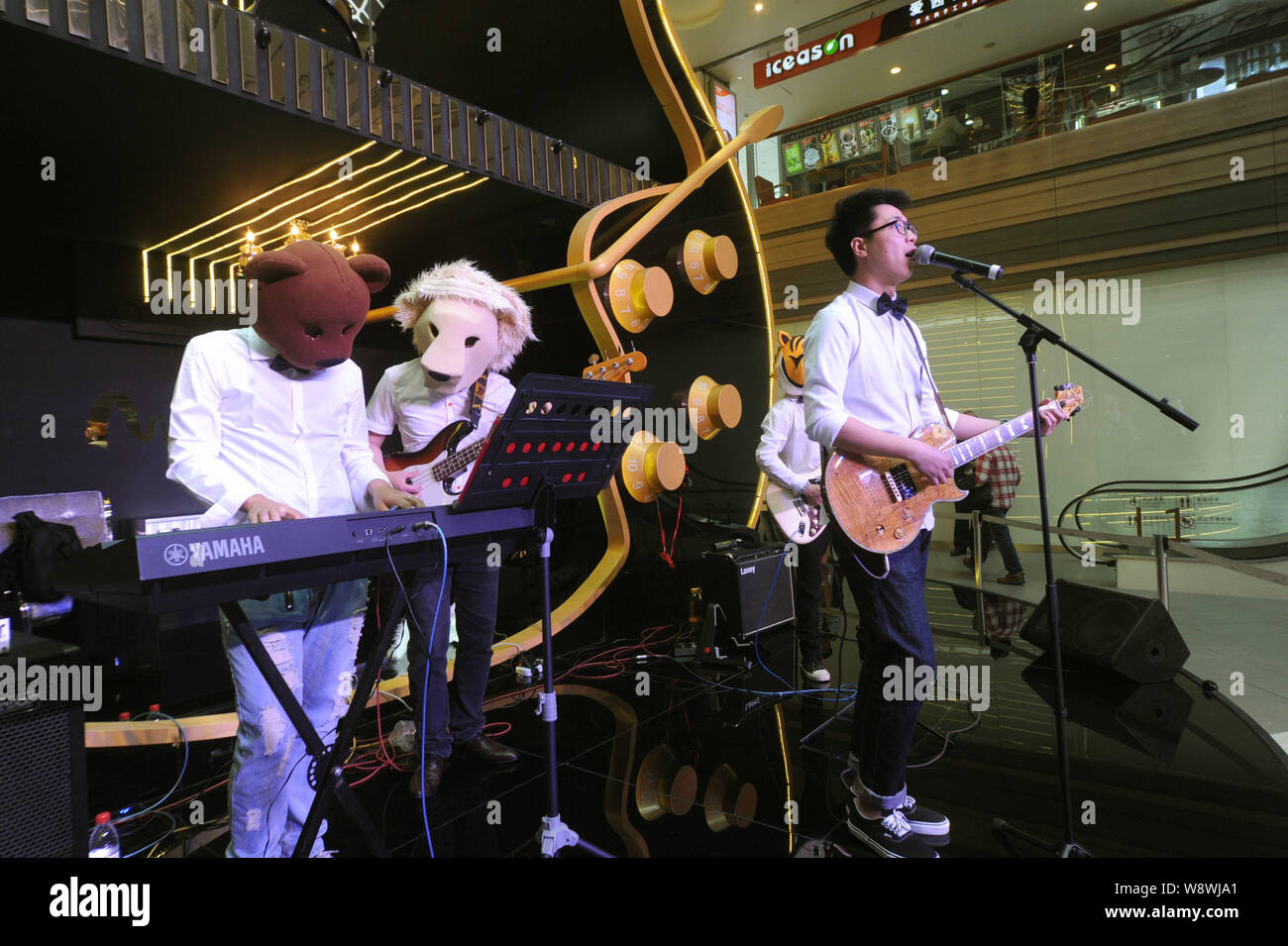A Chinese band performs in front of the 15-meter-tall guitar on display ...