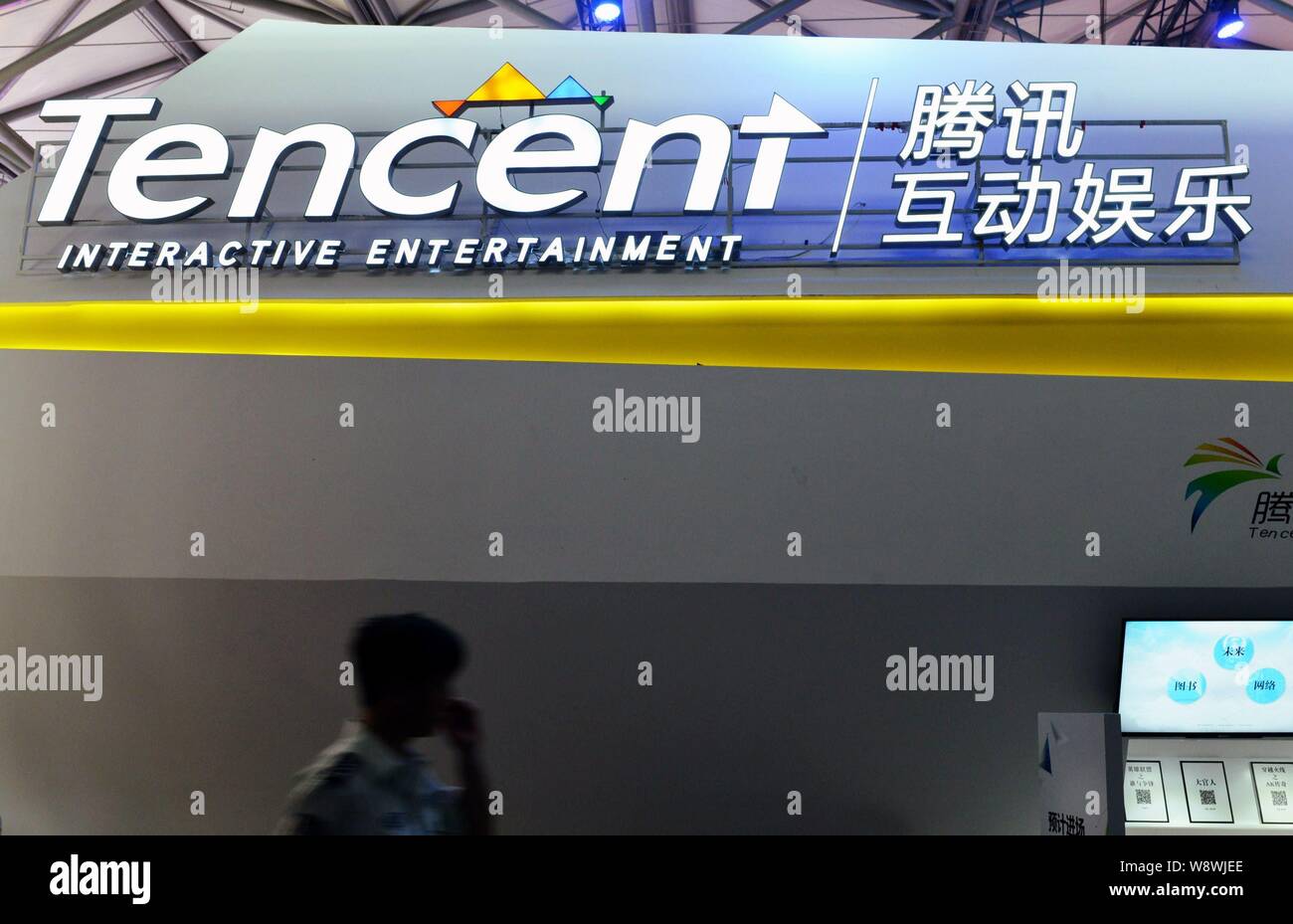 --FILE--A visitor walks past the stand of Tencent Interactive ...
