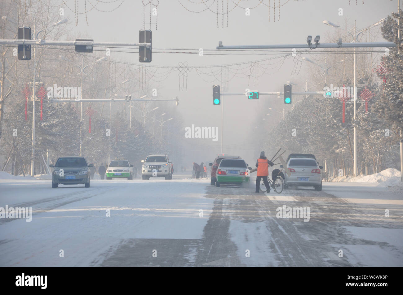 Vehicles move slowly on a road covered with snow in Ergun City of ...