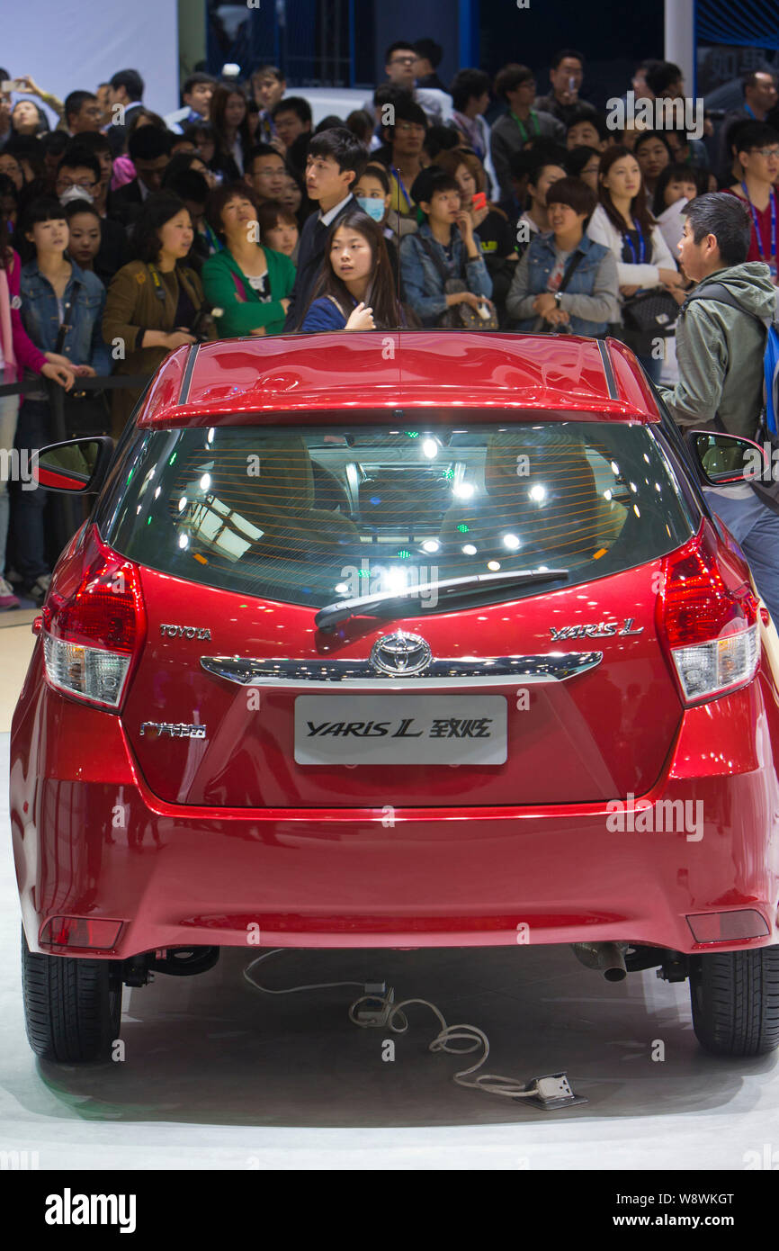 Visitors look at a YARiS L of Toyota during the 13th Beijing ...
