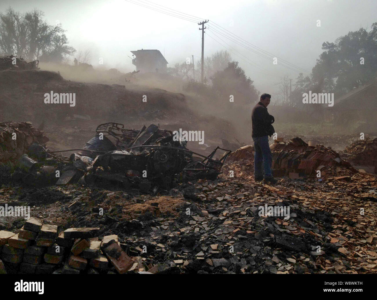 A villager stands on the debris of houses burnt out by the fire in ...