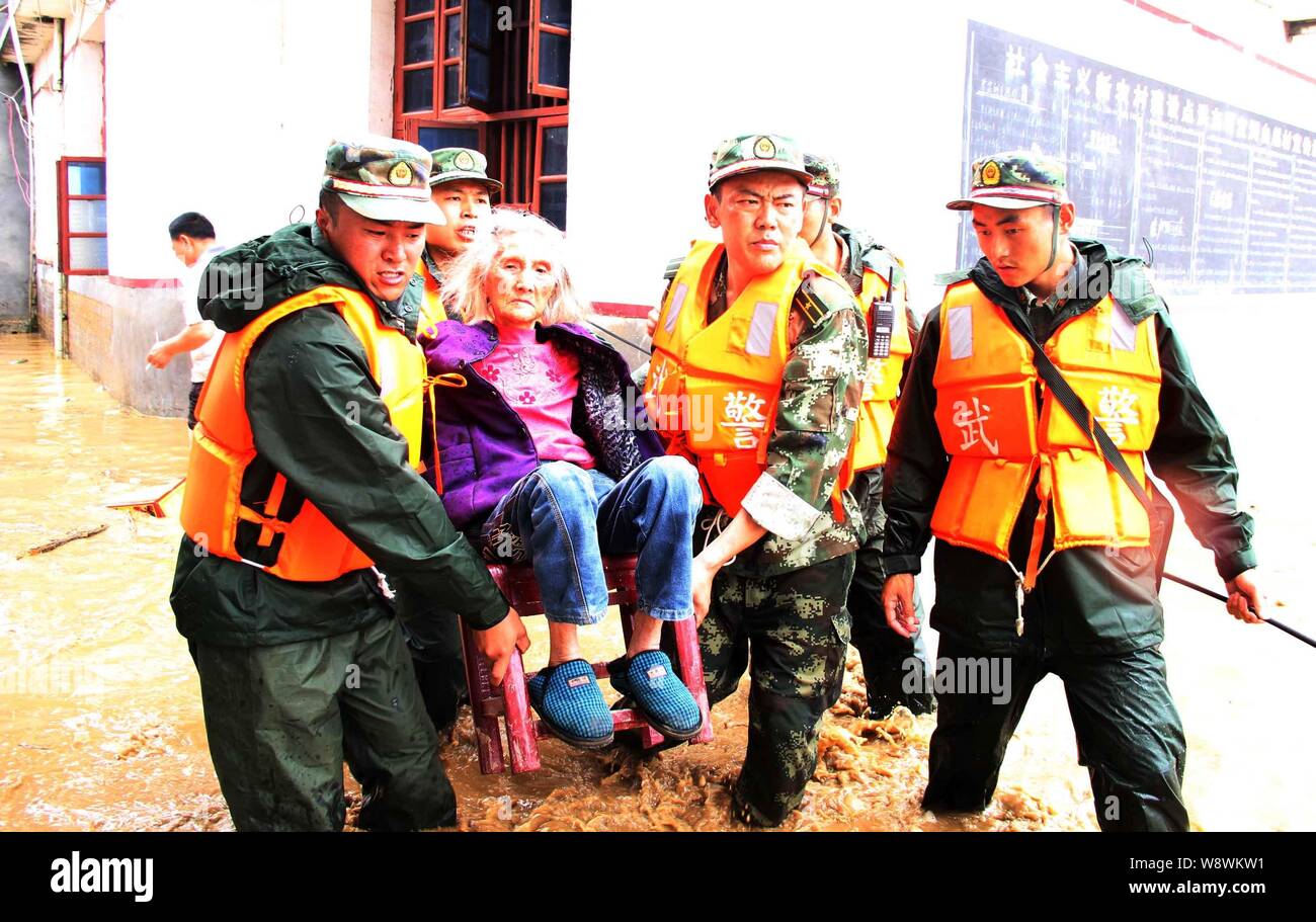 Chinese rescuers evacuate an elderly local resident from flooded areas ...