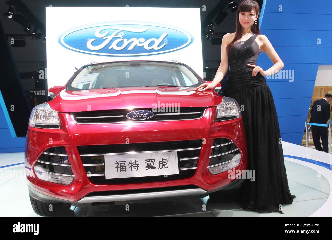 --FILE--A model poses with a Ford Kuga during an automobile exhibition ...