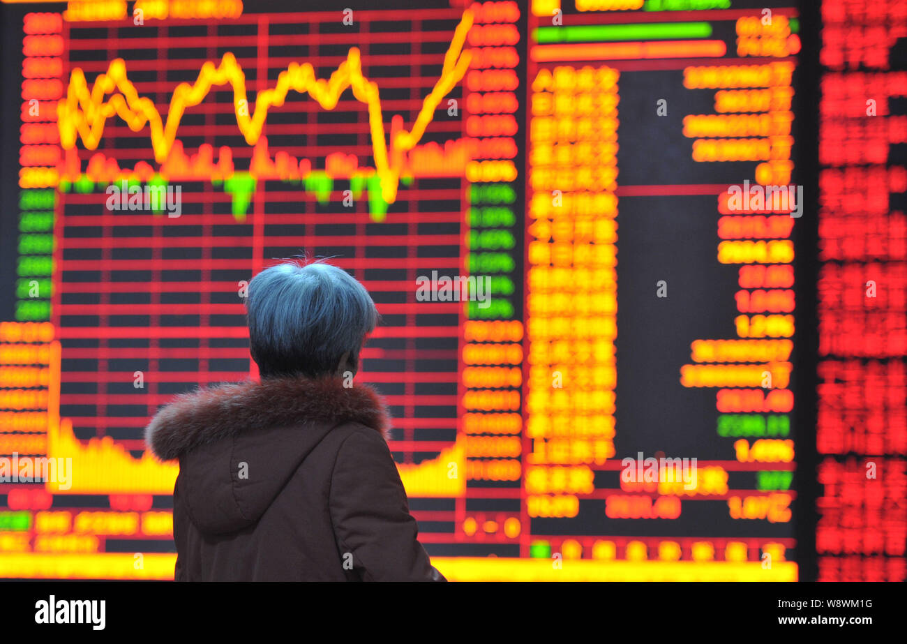 A Chinese investor looks at a stock index at a stock brokerage house in ...