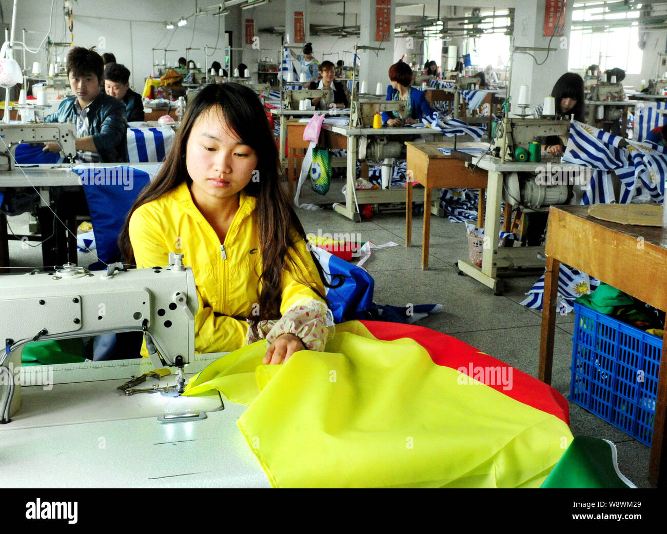 Chinese workers sew national flags of Uruguay, back, and other ...