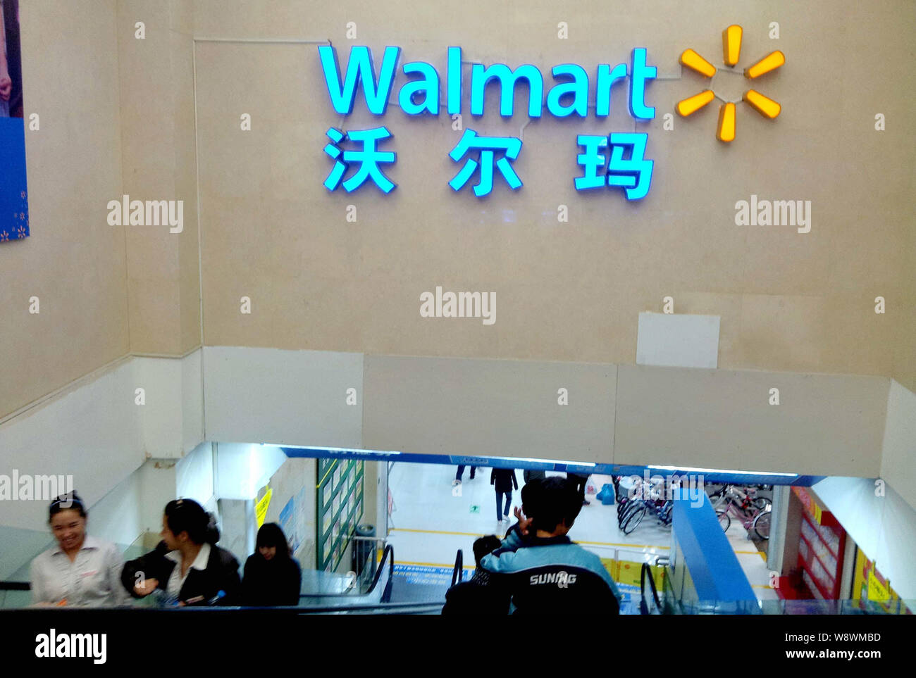--FILE--Chinese customers take escalators at a supermarket of Walmart ...