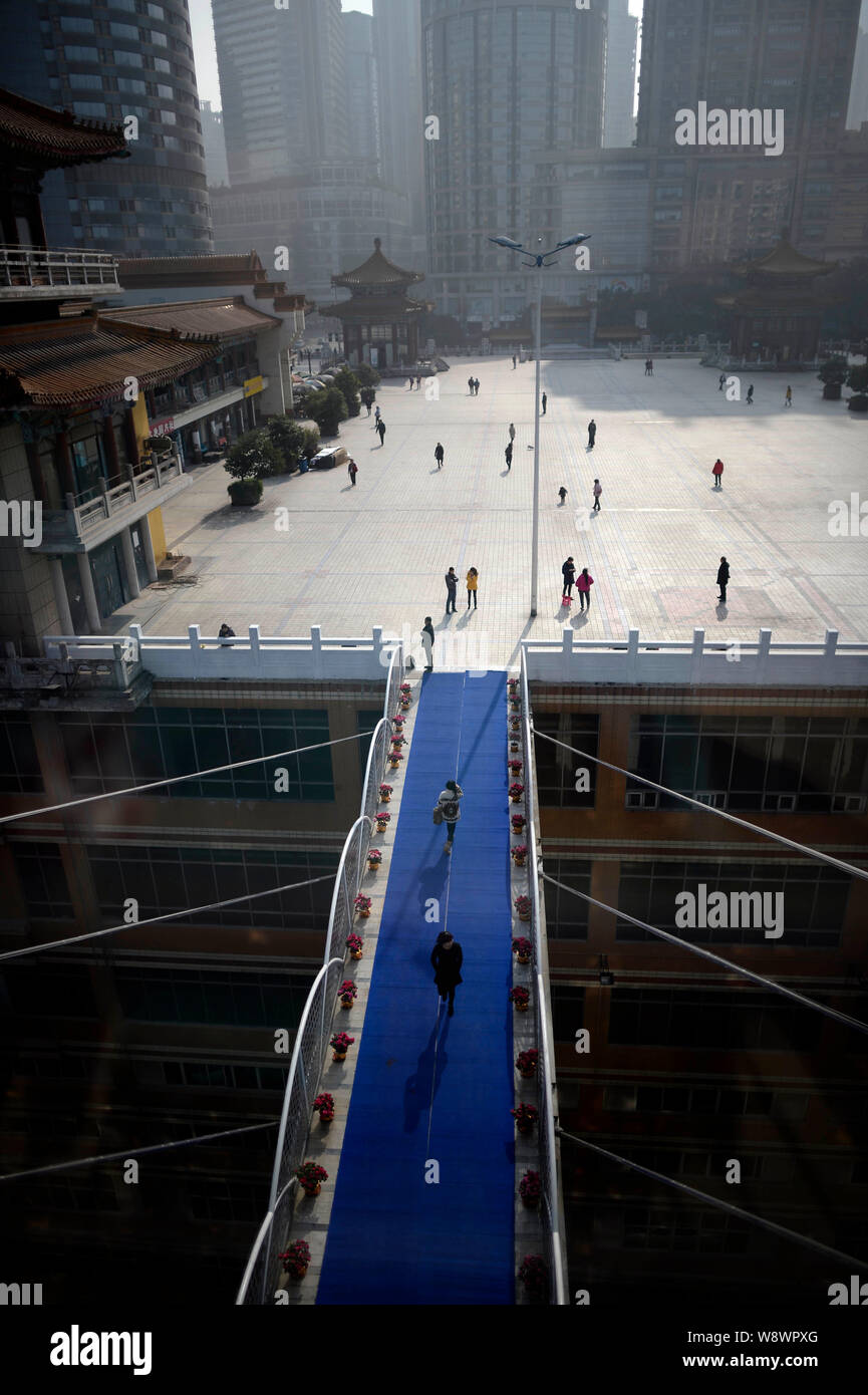 Pedestrians walk on one of the two pedestrian bridges sticking out from ...