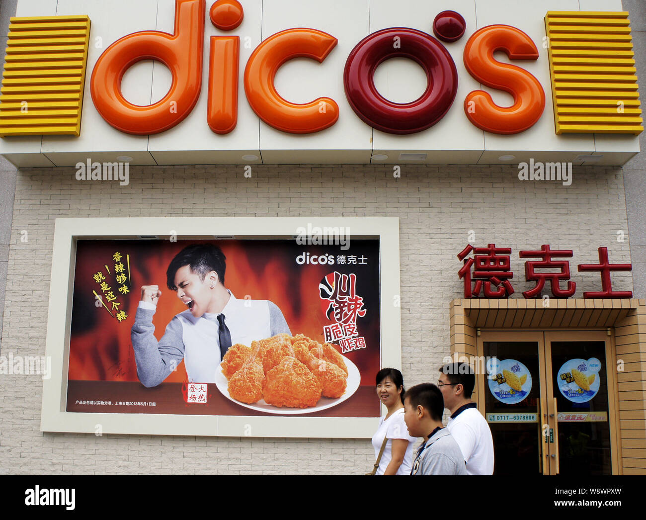 --FILE--Pedestrians walk past a Dicos fastfood restaurant in Yichang ...
