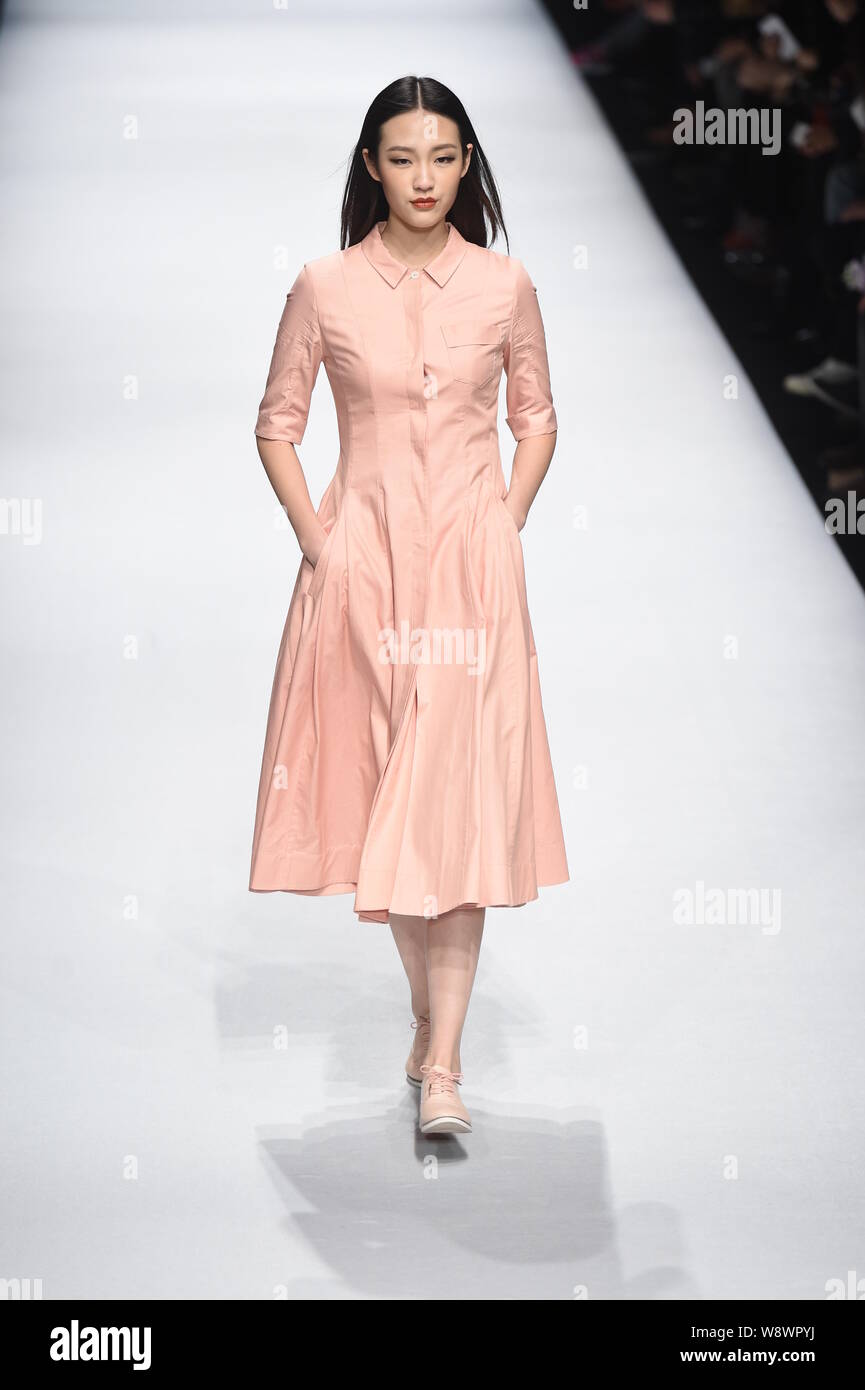 A model displays a new creation by designer Huang Liyong at the ...