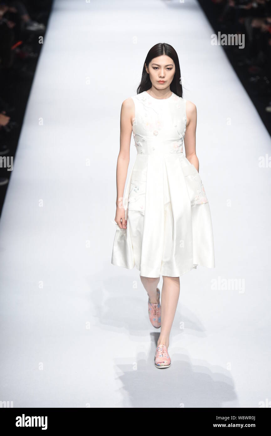 A model displays a new creation by designer Huang Liyong at the ...