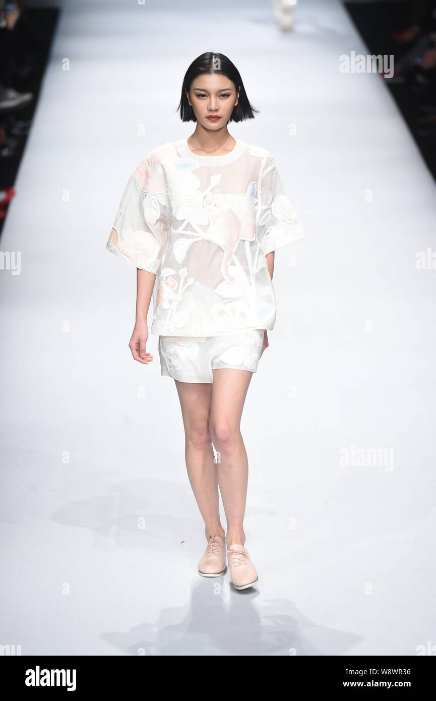 A model displays a new creation by designer Huang Liyong at the ...