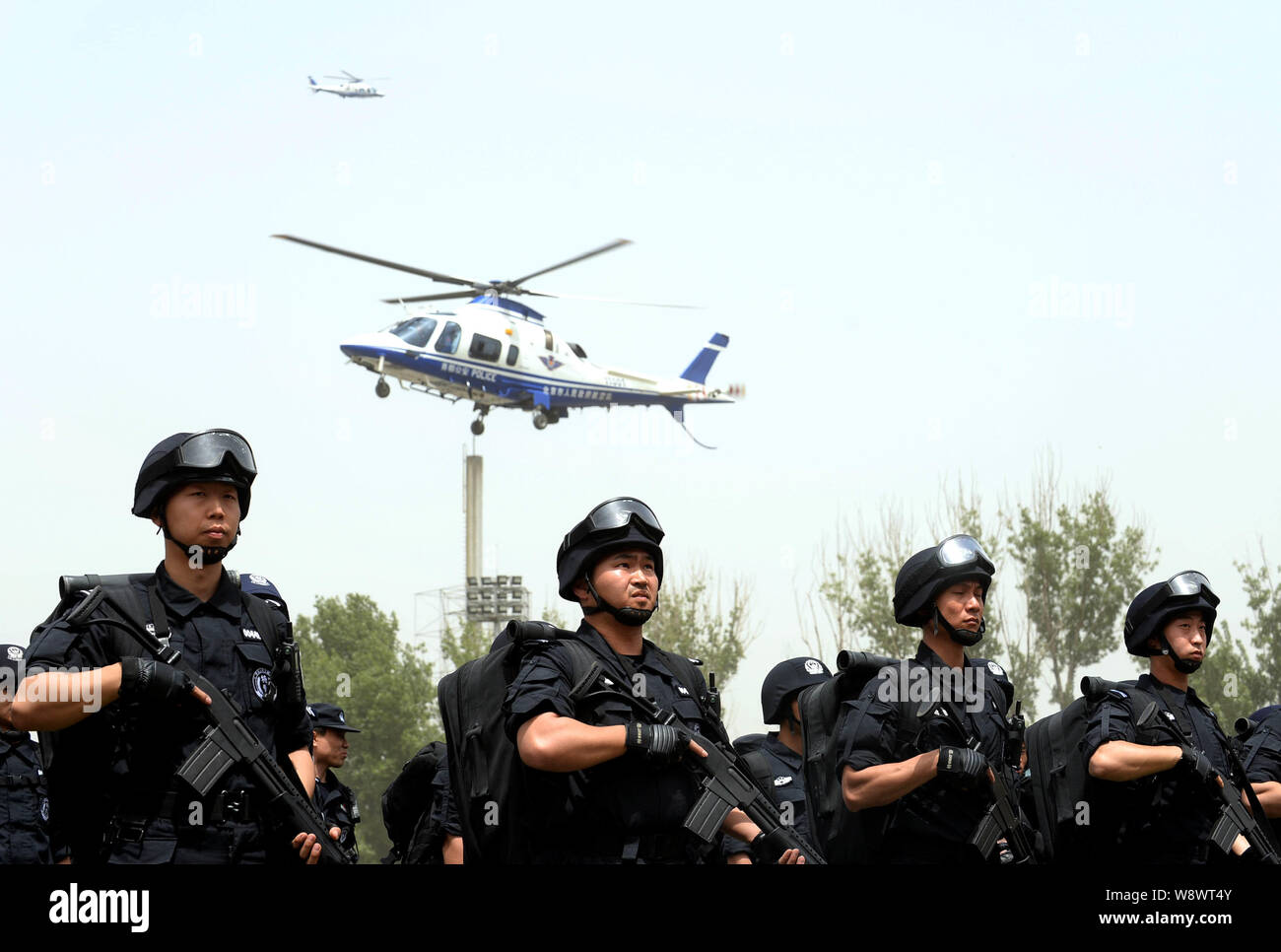 Helicopters and SWAT police officers armed with guns participate in an ...