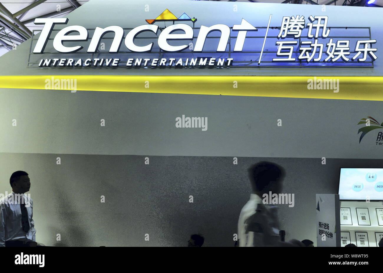 --FILE--Visitors walk past the stand of Tencent Interactive ...