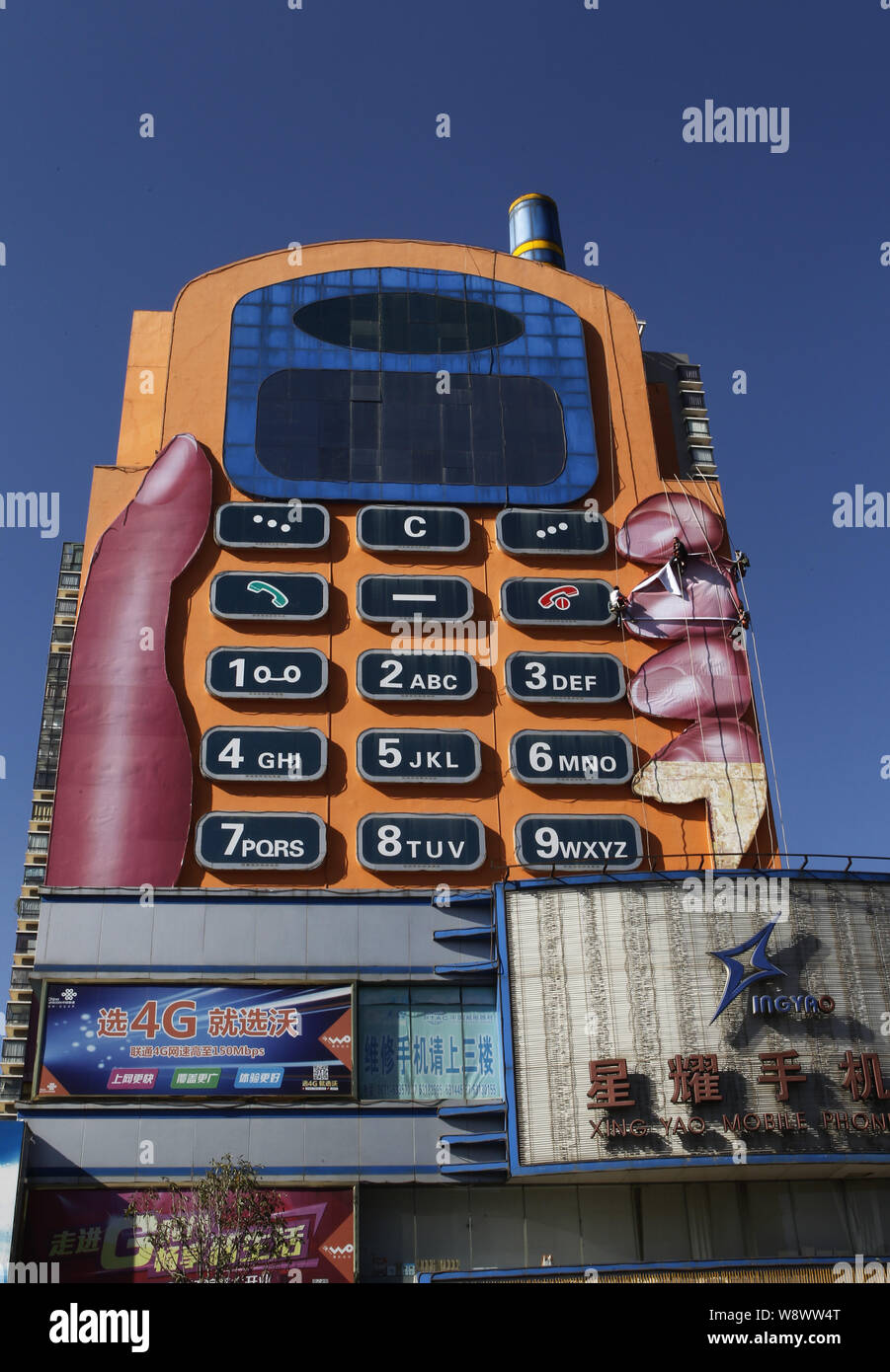 Chinese workers are changing the wall paper of a giant mobile phone ...