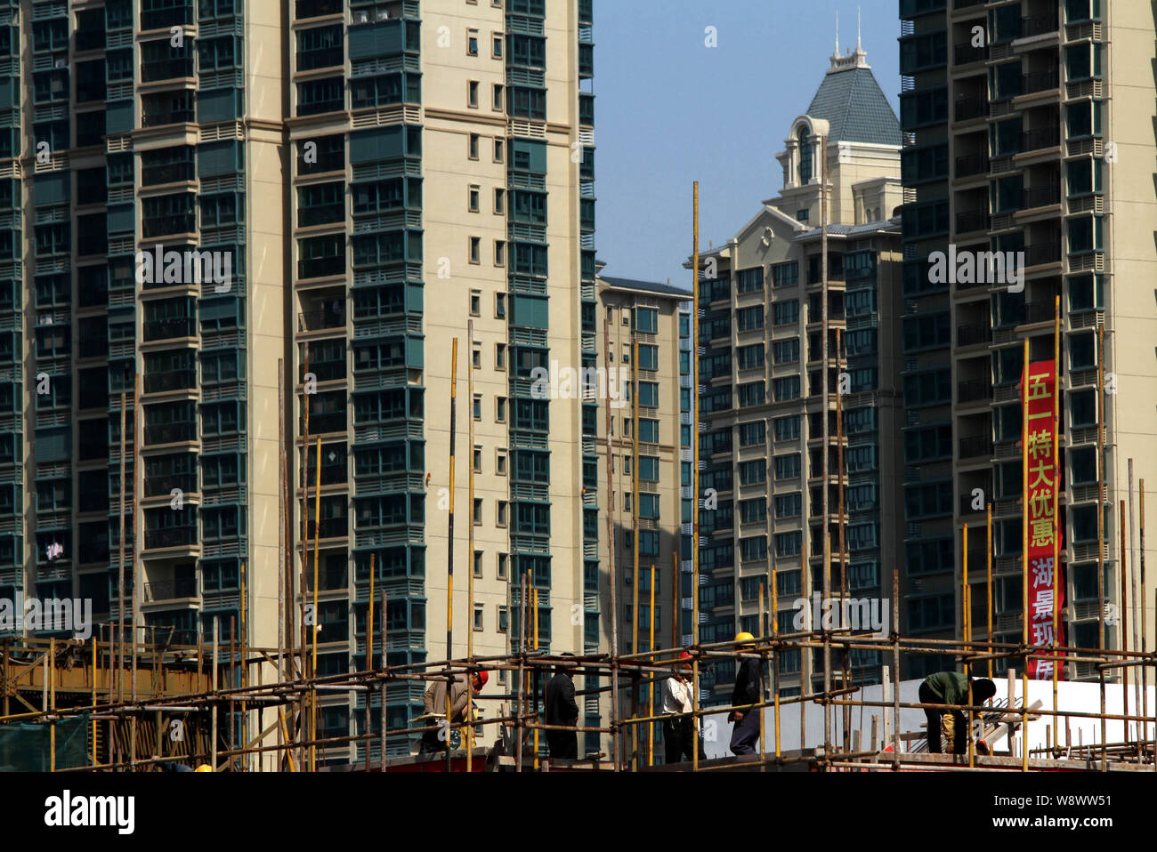 Migrant workers build scaffoldings at the construction site of a ...