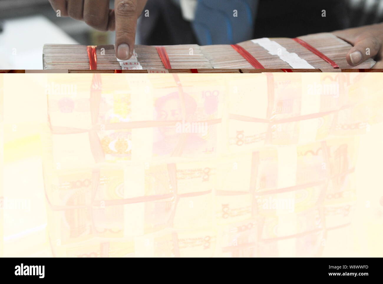 --FILE--A Chinese clerk counts RMB (renminbi) yuan banknotes at a ...