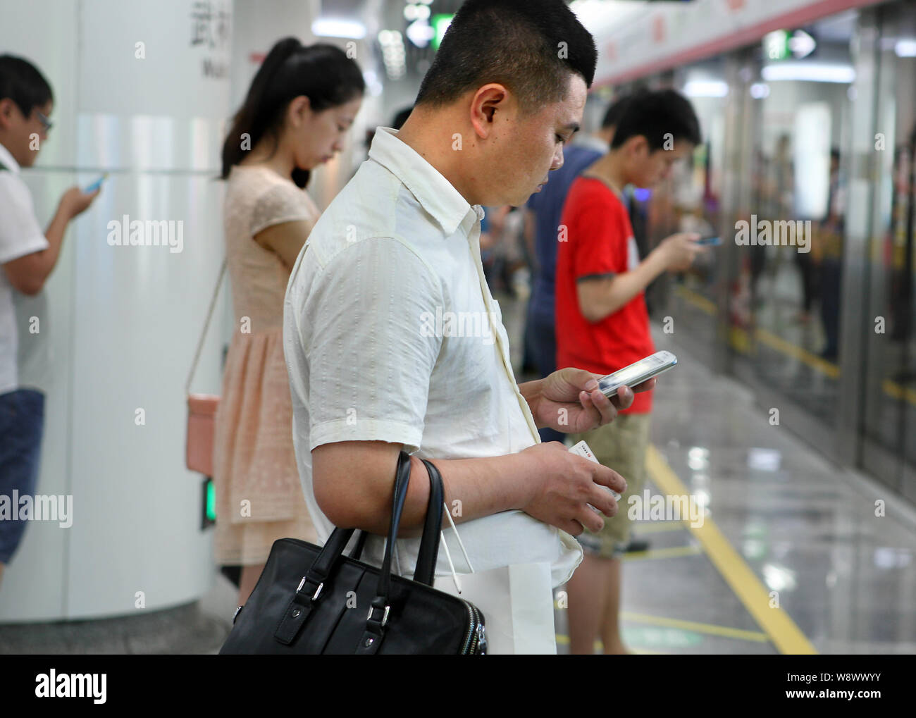 --FILE--Passengers use their smartphones to surf the Internet as they ...