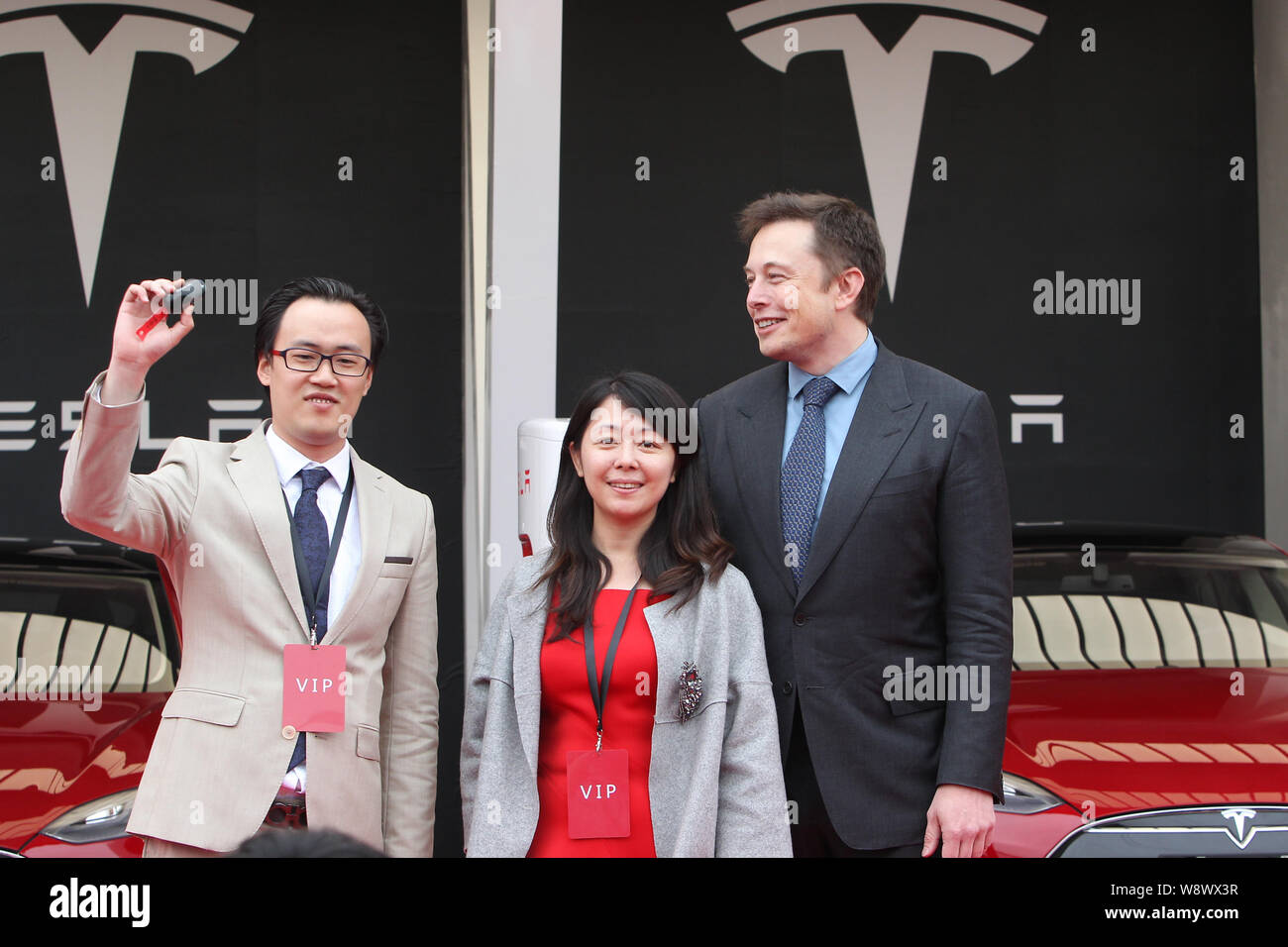 Tesla CEO Elon Musk, right, poses with buyers of Tesla Model S electric ...