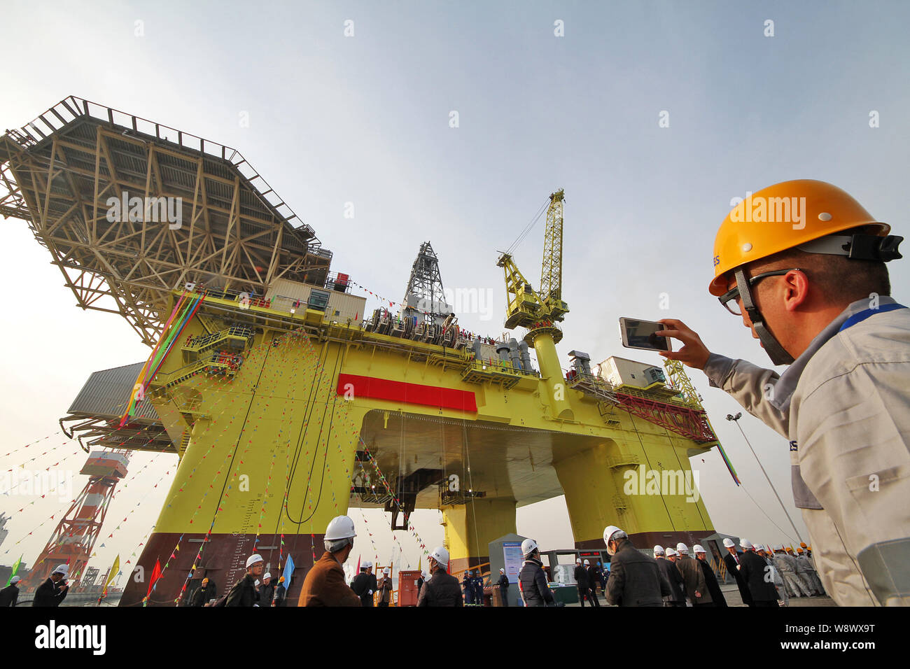 A Chinese worker takes photos of the deepwater oil rig "COSLProspector ...