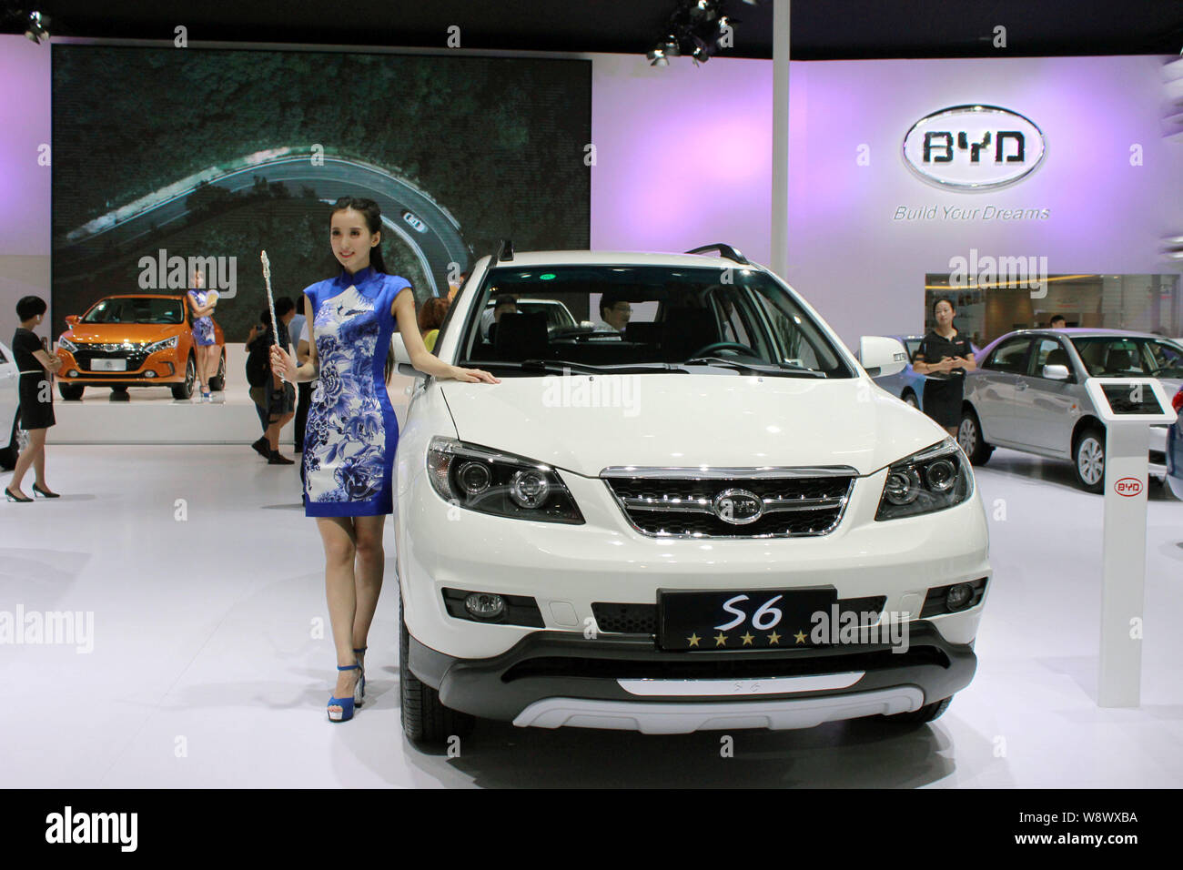 --FILE--A model poses with a BYD S6 during an auto show in Chengdu city ...