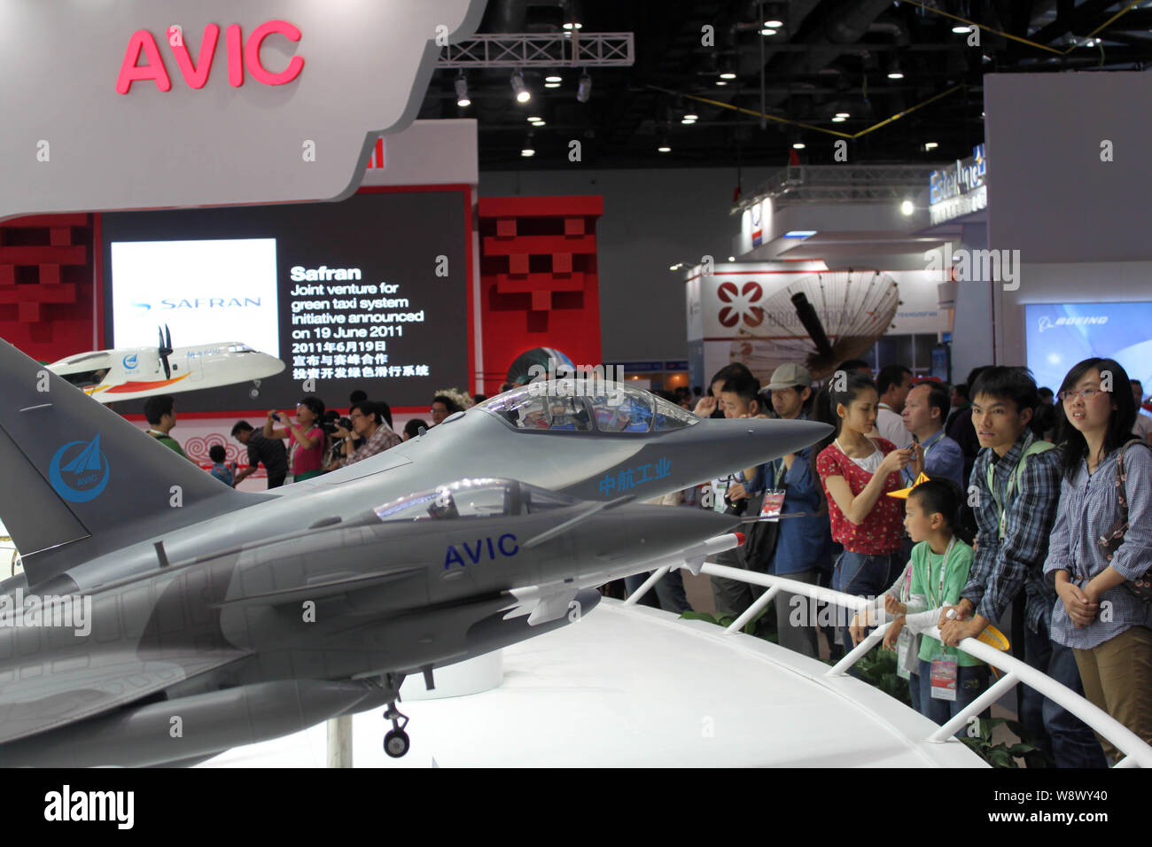 --FILE--Visitors take photos of model planes at the stand of AVIC ...