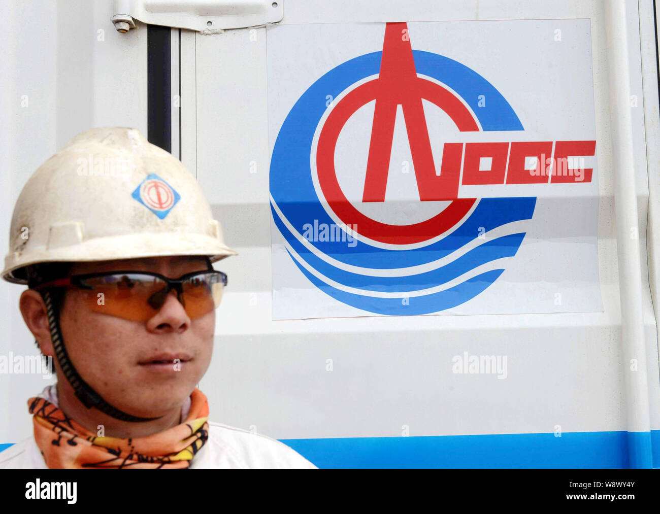 --FILE--A Chinese worker stands in front of a container with the logo ...