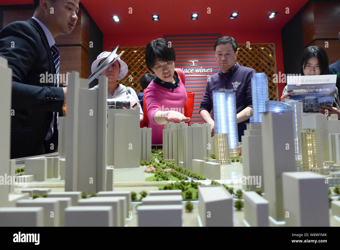 Chinese visitors view housing models of a residential project at a real ...