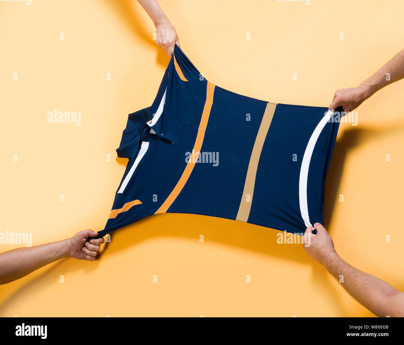 Four hands pulling the shirt Stock Photo - Alamy