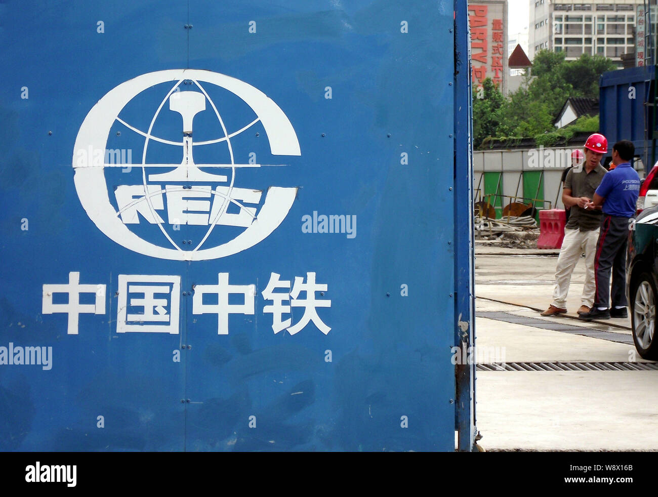 --FILE--Migrant workers talk next to an advertisement for CREC (China ...