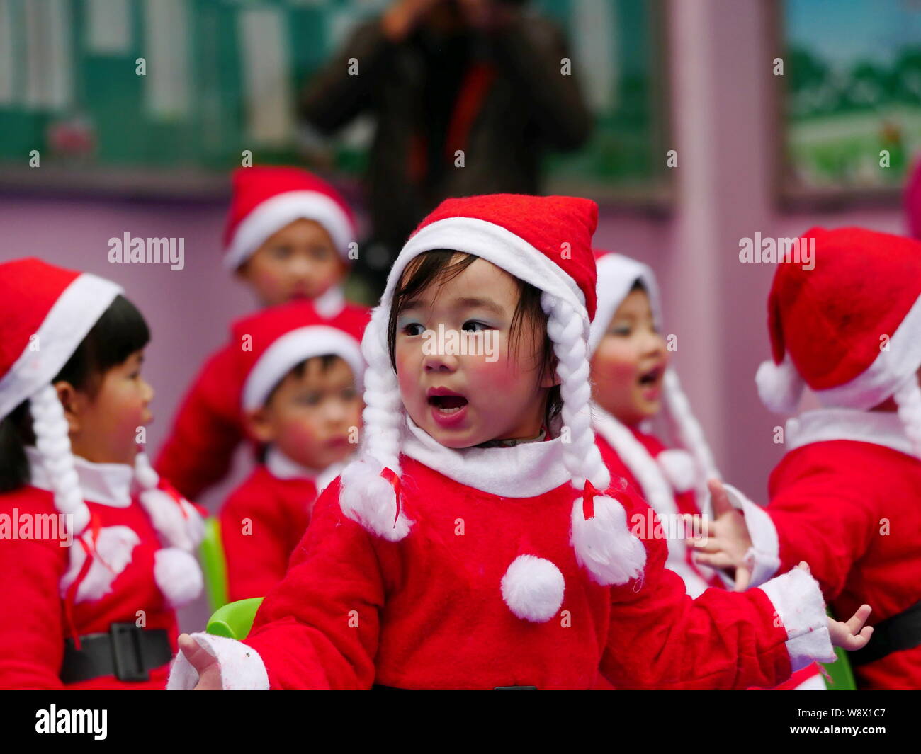 Young kids dressed in Santa Claus costumes take part in a performance ...
