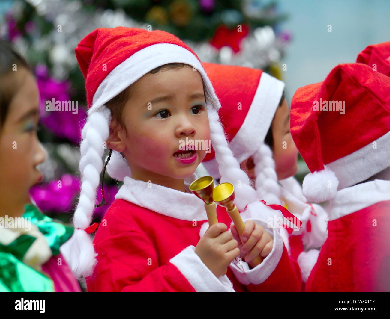 Young kids dressed in Santa Claus costumes take part in a performance ...
