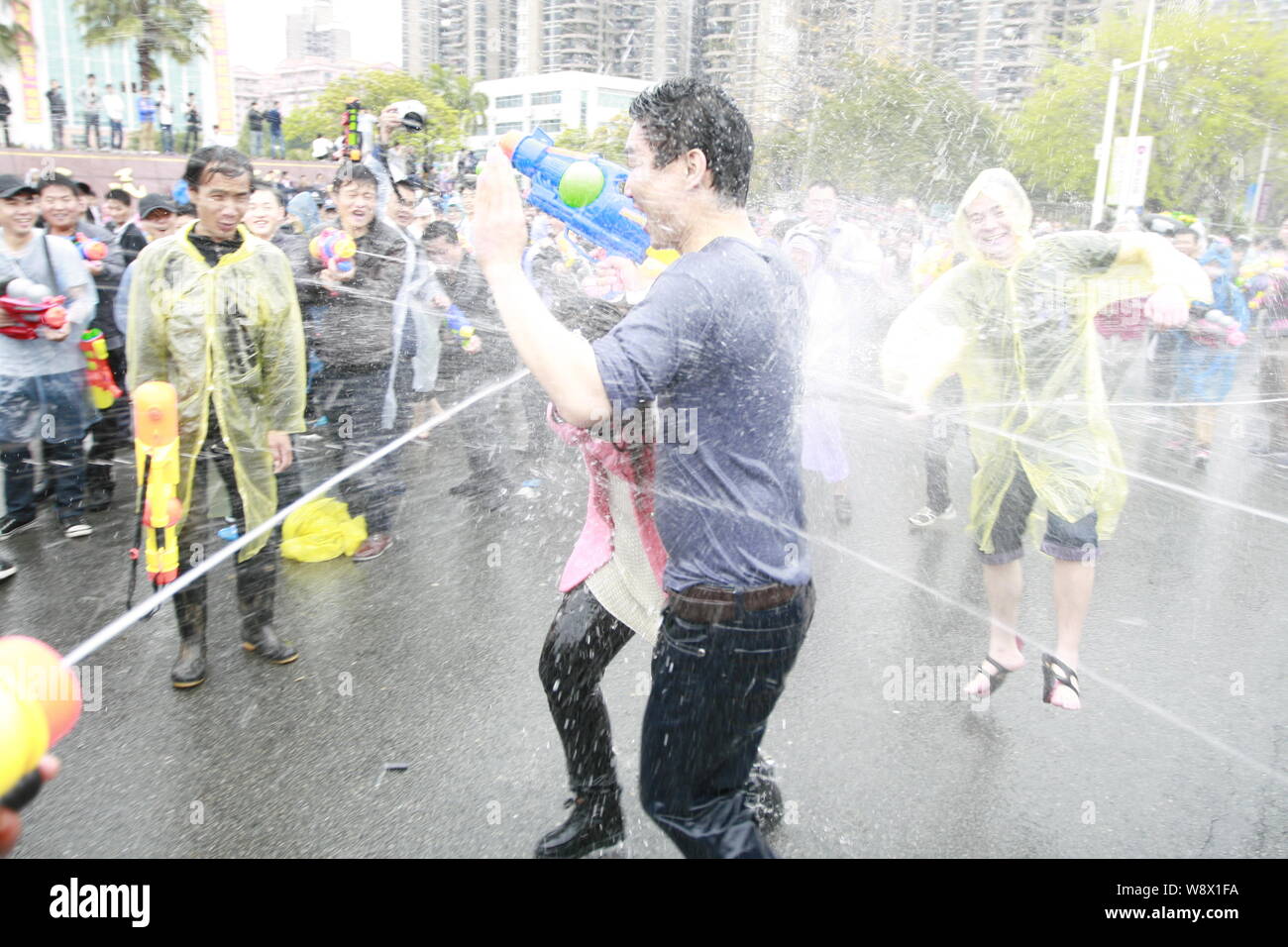 Local residents shoot one another with water guns during the Water ...