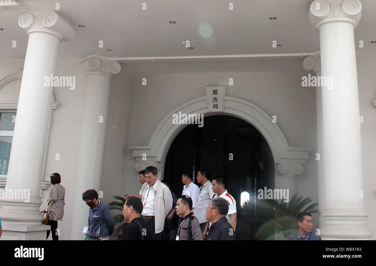 Local residents crowd in front of a public toilet resembling the United ...